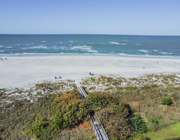 Perto da praia, areia branca, espreguiçadeiras, guarda-sóis