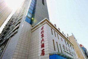Um edifício com entrada destacada e sinalização indicando um hotel.