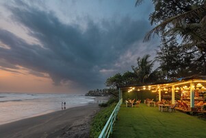 Um restaurante à beira-mar com mesas ao ar livre e vista para o oceano.