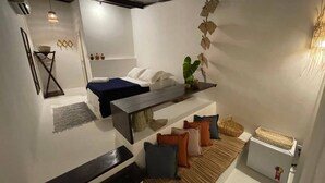 Quarto compacto com cama, um espaço de estar pequeno e uma cozinha compacta.