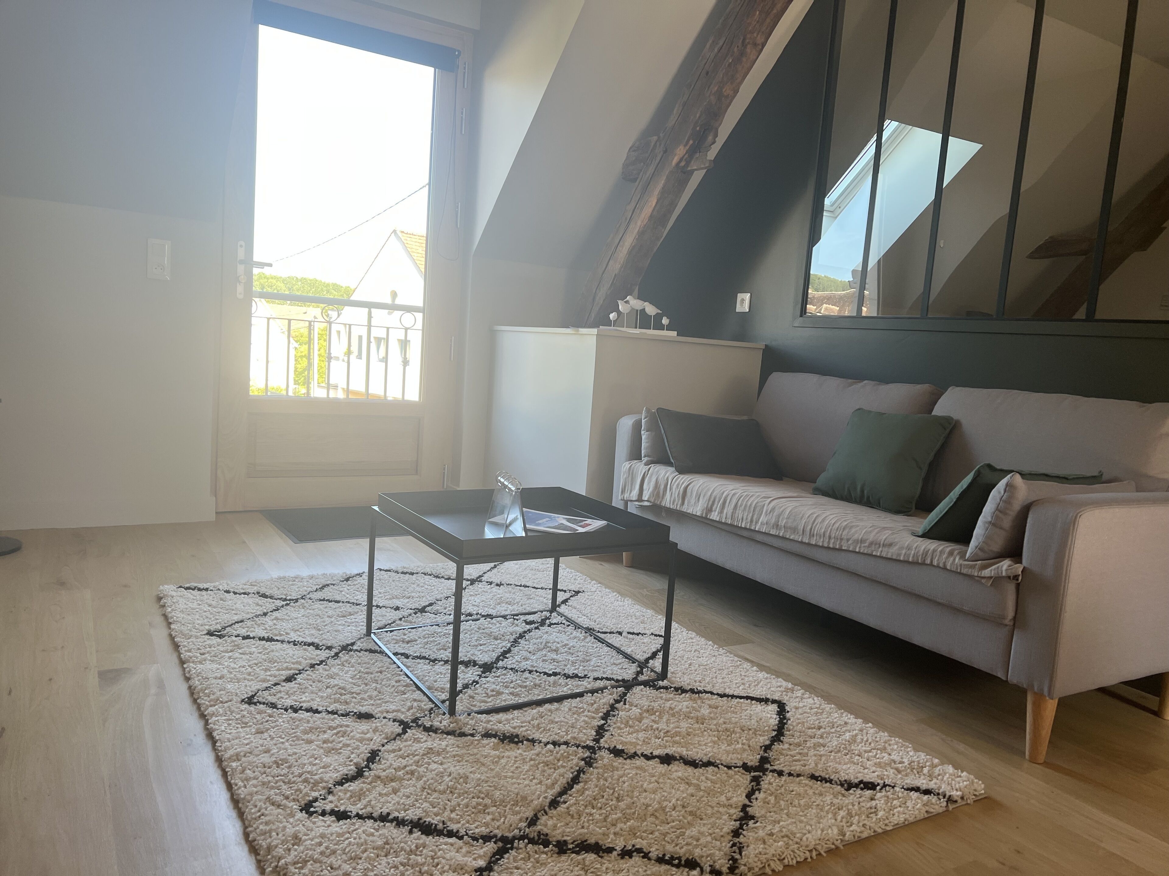 Uma sala de estar moderna com um sofá, uma mesa de centro e um tapete geométrico.