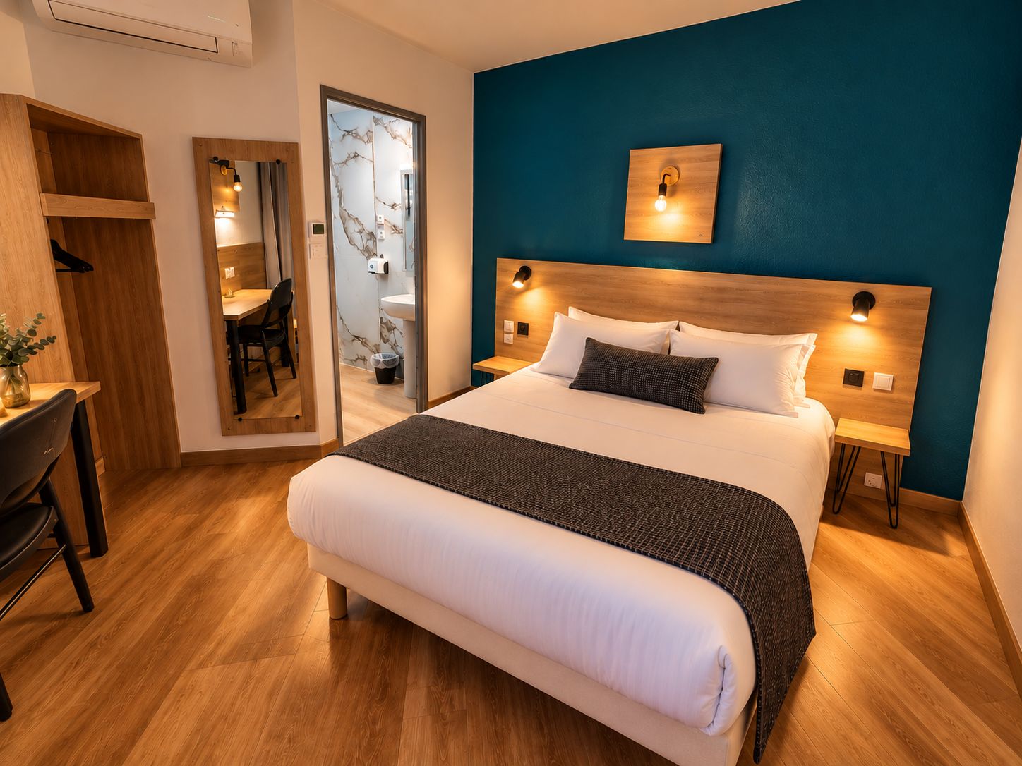 Quarto de hotel com uma cama grande, mesas de cabeceira, escrivaninha e espelho.