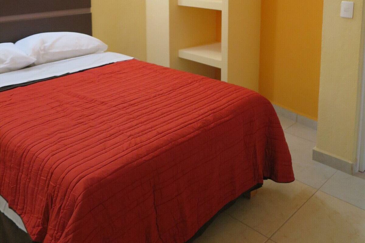 Quarto com cama, guarda-roupa e estante embutida.
