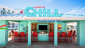 Um bar e churrascaria à beira-mar, com uma placa que diz 'License to Chill'.