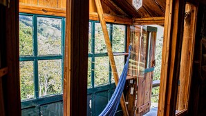 Uma cabana de madeira com janelas amplas e uma rede.