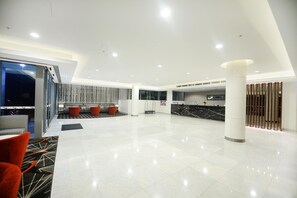 Um hall amplo com balcão de recepção, área de estar e design moderno.