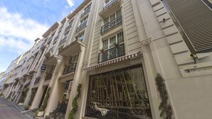 Uma fileira de edifícios altos com varandas, janelas amplas e céu claro.