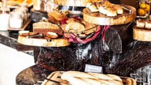 Uma mesa de buffet com diversos alimentos e um arranjo decorativo.