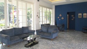 Um hall amplo com janelas grandes, paredes azuis e carpete estampado.