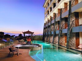 Um hotel com área de piscina, incluindo uma banheira de hidromassagem e cadeiras de sol.