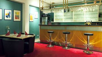 Uma área de bar com balcão, banquetes e geladeira.