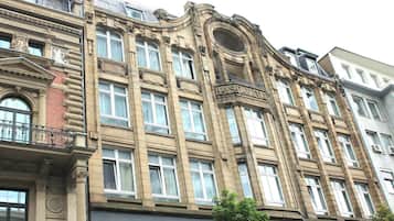 Um edifício histórico com detalhes arquitetônicos elaborados, várias janelas e uma entrada imponente.