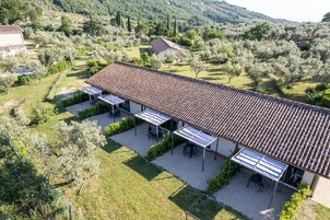 Uma villa com telhado em telhas, painéis solares e um alpendre com área de estar ao ar livre.