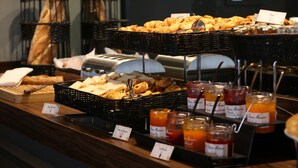 Um buffet com diversos alimentos e acompanhamentos.