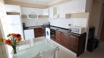Apartamento, 3 quartos | Kitchenette privada | Um frigorífico/congelador grande, um micro-ondas, uma placa de cozinha
