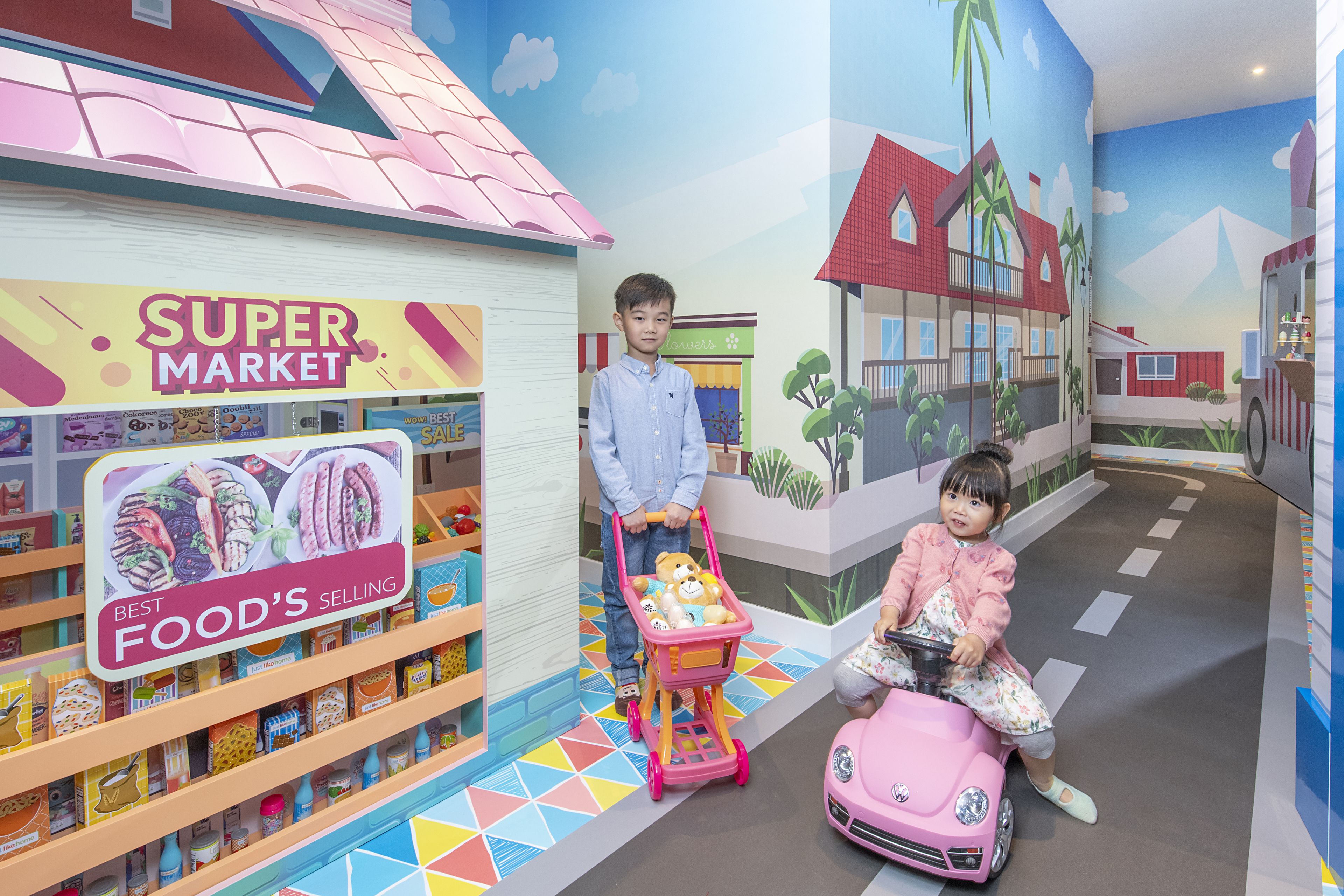 Uma área de recreação infantil com uma placa 'Super Market' e uma placa 'Best Food's Selling'.