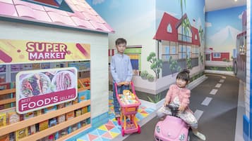 Uma área de recreação infantil com uma placa 'Super Market' e uma placa 'Best Food's Selling'.