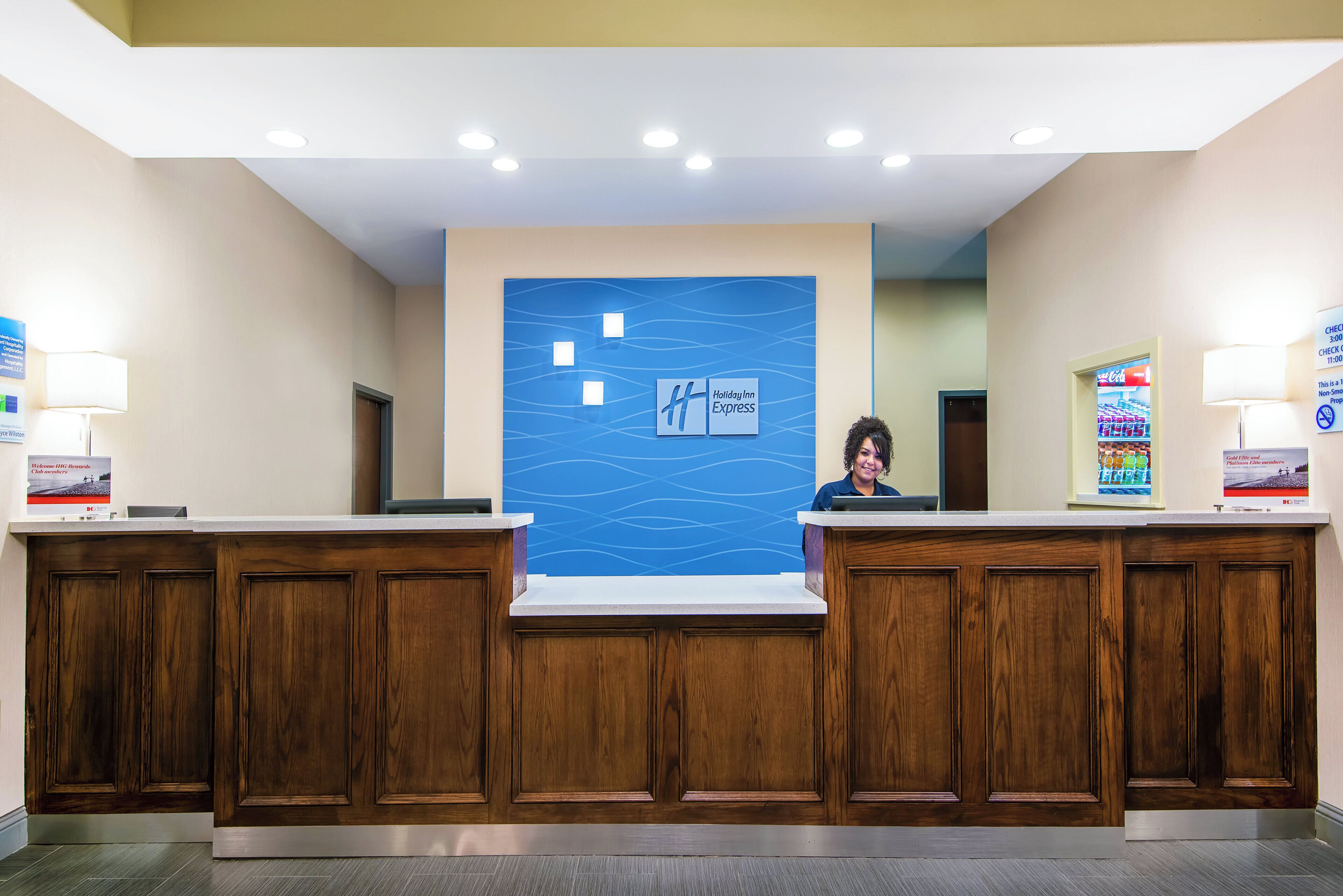 Balcão de recepção de hotel com parede azul e placa da Holiday Inn Express.