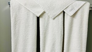 Uma toalha branca pendurada em um porta-toalhas de metal.