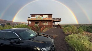 Um edifício de madeira com uma placa que diz 'Rim Rock Restaurant' e um carro estacionado em frente.