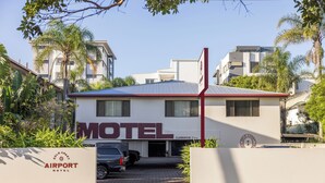 Um motel com uma placa indicando 'AIRPORT HOTEL' e 'CLEARANCE 2-1-6'.