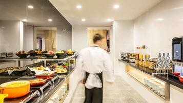 Cozinha moderna com serviço de buffet, incluindo diversas opções de comida e um espaço para café.