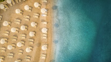 Perto da praia, espreguiçadeiras, guarda-sóis 