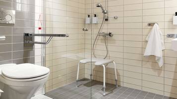 Um banheiro moderno com vaso sanitário, chuveiro com porta de vidro e porta-toalhas.