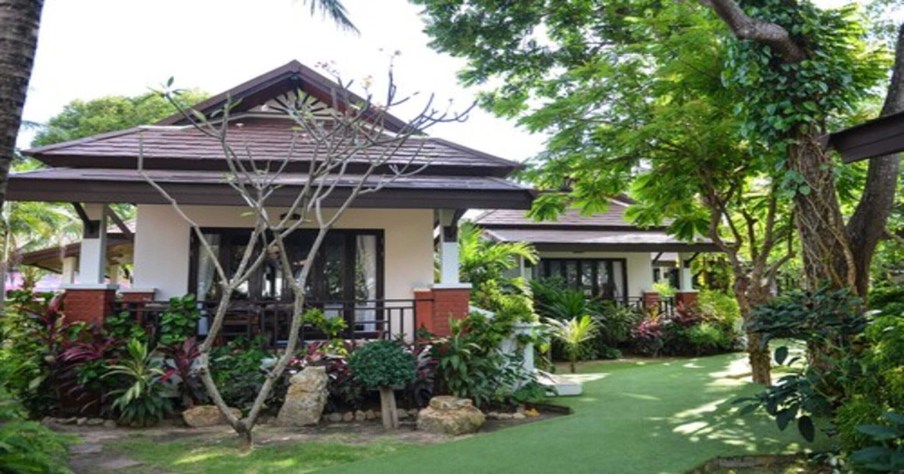 Uma casa de dois andares com um jardim na frente.
