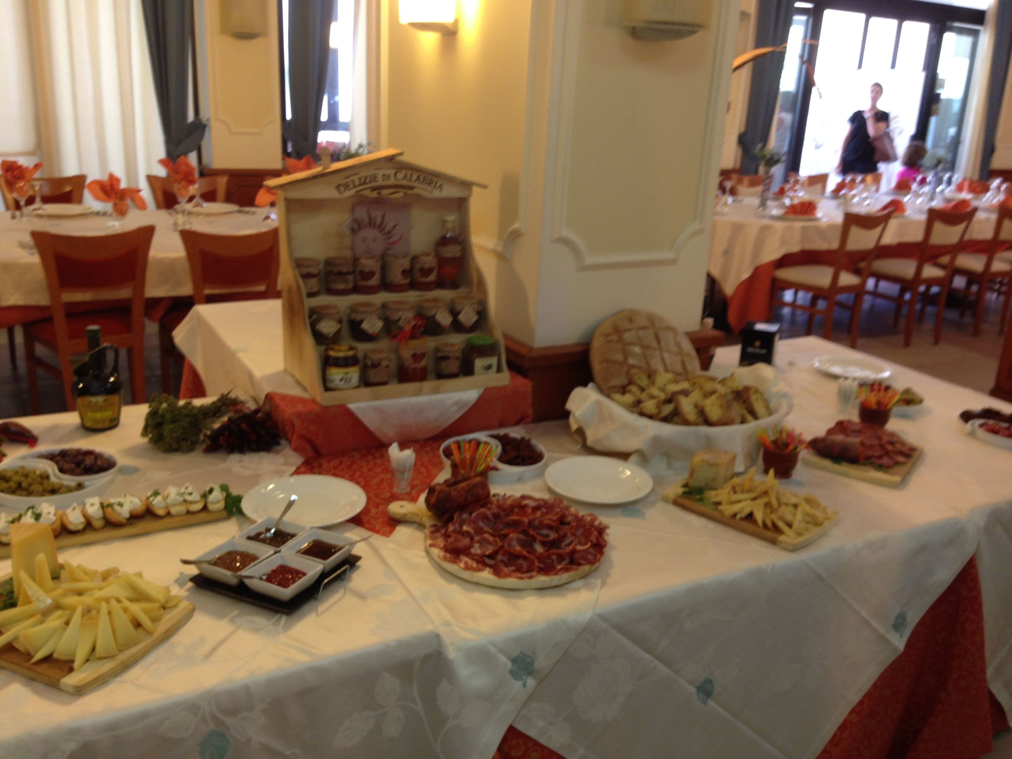 Uma mesa de buffet com diversos alimentos e uma exposição de potes.