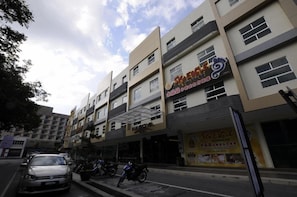Um edifício com vários andares e estabelecimentos comerciais no andar térreo, incluindo uma sala de massagem.