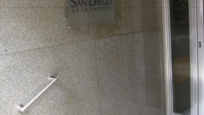Placa de San Diego Apartments com corrimão de metal e porta de vidro.