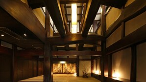 Interior japonês tradicional com tatames, vigas de madeira e painéis shoji.