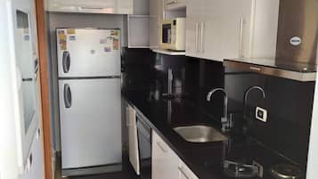 Apartamento, 4 quartos | Cozinha privada | Geladeira, micro-ondas, fogão, cooktop