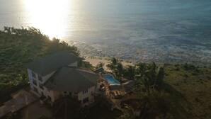 Um imóvel à beira-mar com piscina, uma casa grande e vista para o oceano.