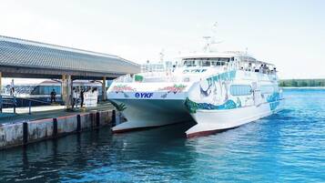 Um ferry atracado num cais com zona de espera coberta e vista desimpedida para a água.