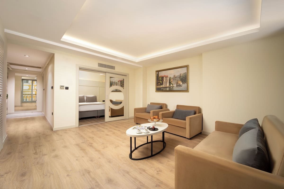 Uma sala de estar moderna com um conjunto de sofá, uma mesa de centro e um quadro na parede.