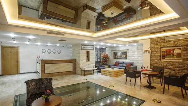 Um hall amplo com mesa de centro de vidro, área de estar e balcão de recepção.