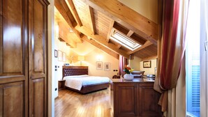 Um quarto espaçoso com uma cama grande, vigas de madeira no teto e um claraboia.