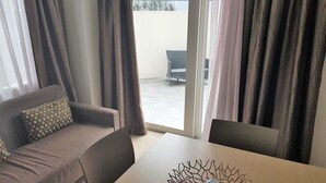 Quarto com sofá, mesa e vista para o exterior.