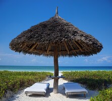 Na praia, barracas de praia de cortesia, espreguiçadeiras, guarda-sóis 