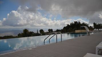 Piscina exterior sazonal, uma piscina transbordante, guarda-sóis