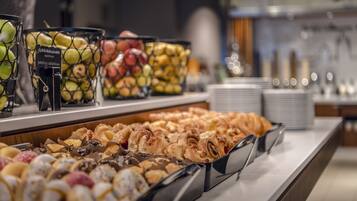 Um buffet com diversos doces e frutas.