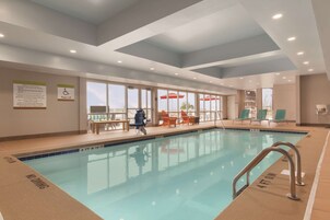 Piscina interior com água cristalina, elevador de piscina e espreguiçadeiras.