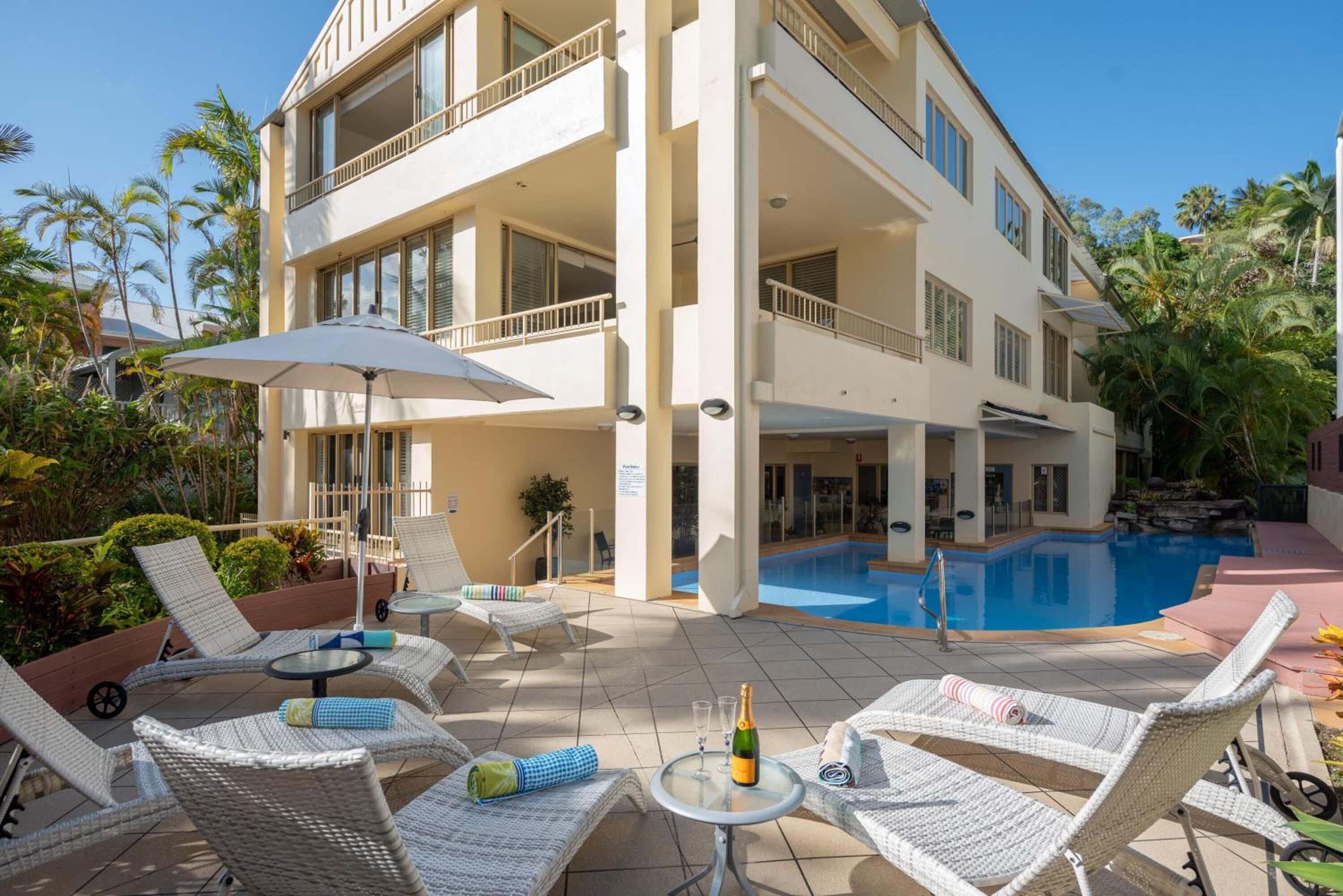 Hotel com piscina, área de estar externa e estrutura em dois andares.