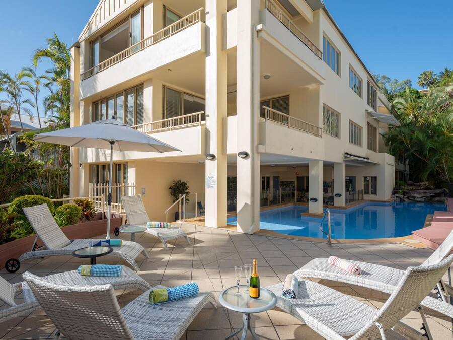 Hotel com piscina, área de estar externa e estrutura em dois andares.