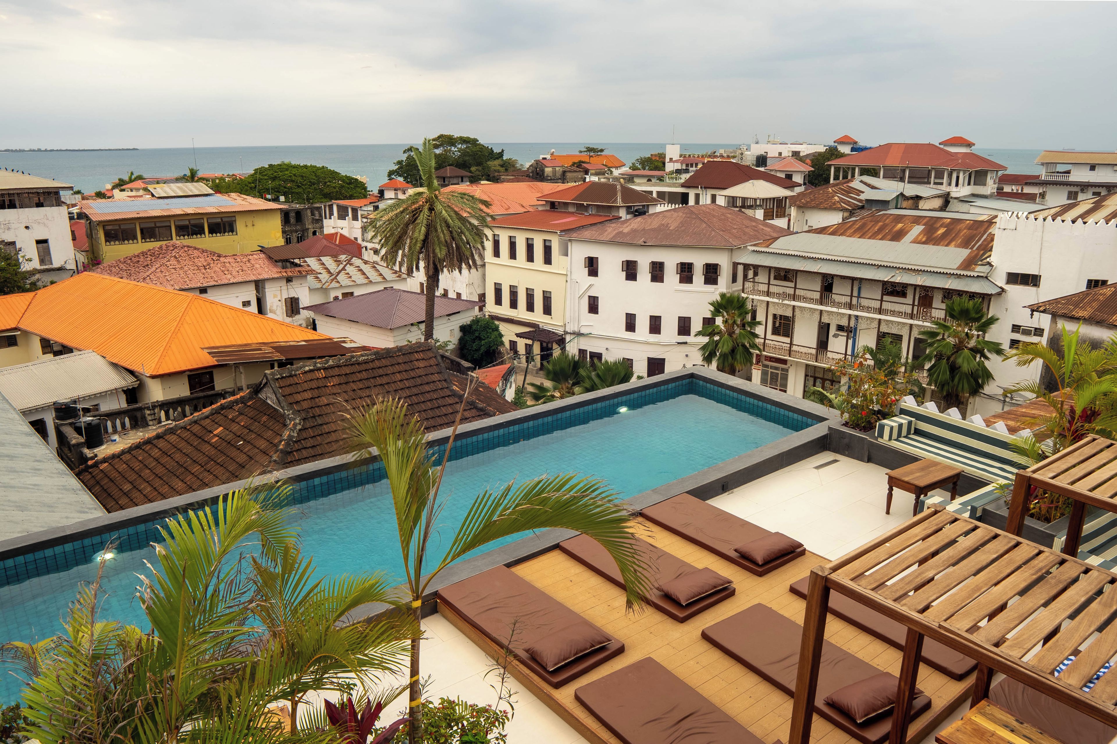 Hotel com piscina, área de estar e vista para o mar.