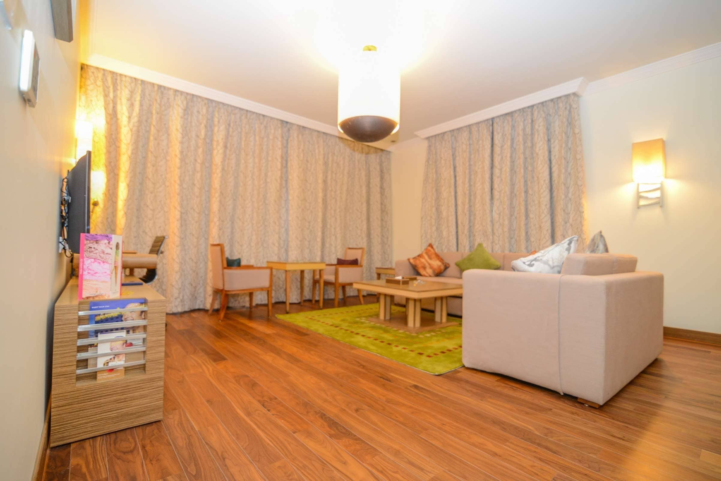 Uma sala de estar moderna com sofá, mesa de centro e área de jantar com cadeiras e mesa.