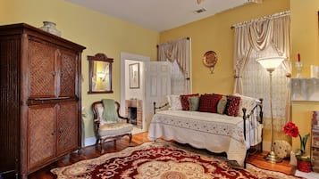 Quarto com cama, armário de madeira, cadeira, abajur e tapete.