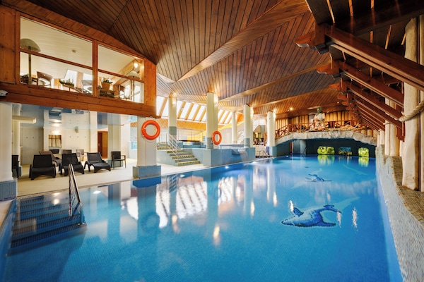 Piscina interior, espreguiçadeiras, nadadores-salvadores no local